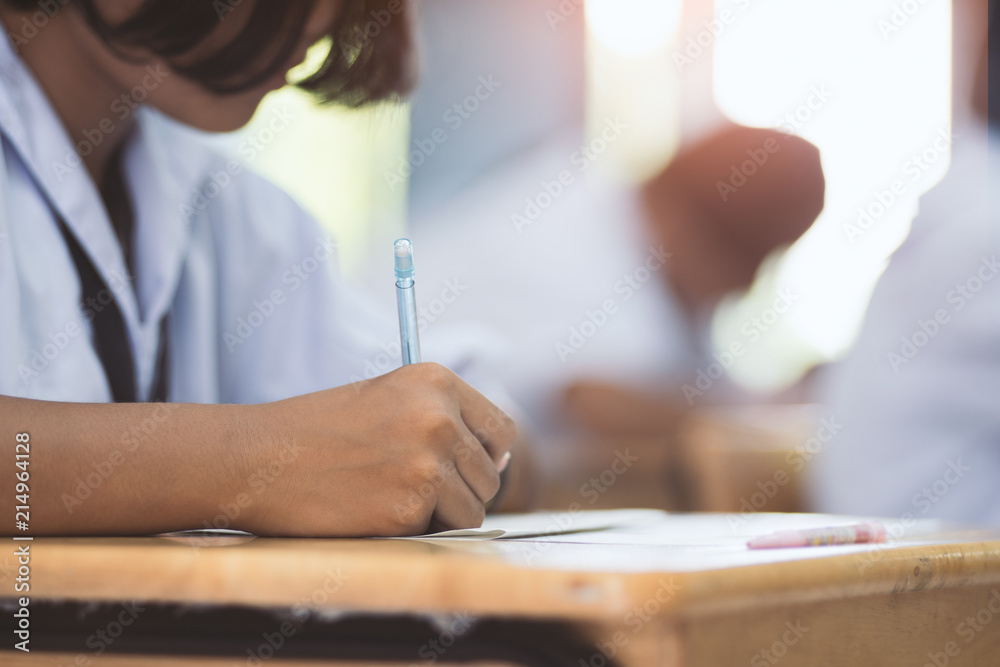 Hand of students in high school uniform holding pen writing on paper ...