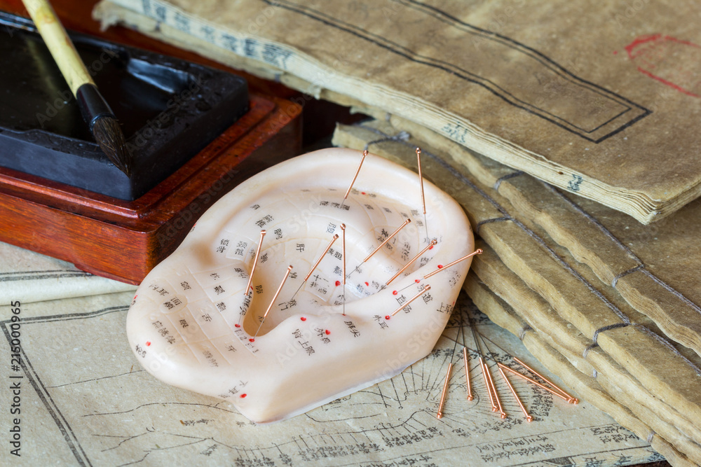 Ear model and needle for ear acupuncture with ancient medicine books at ...