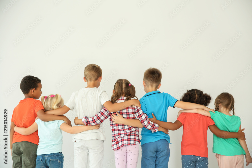 Little children hugging each other with hands on light background ...