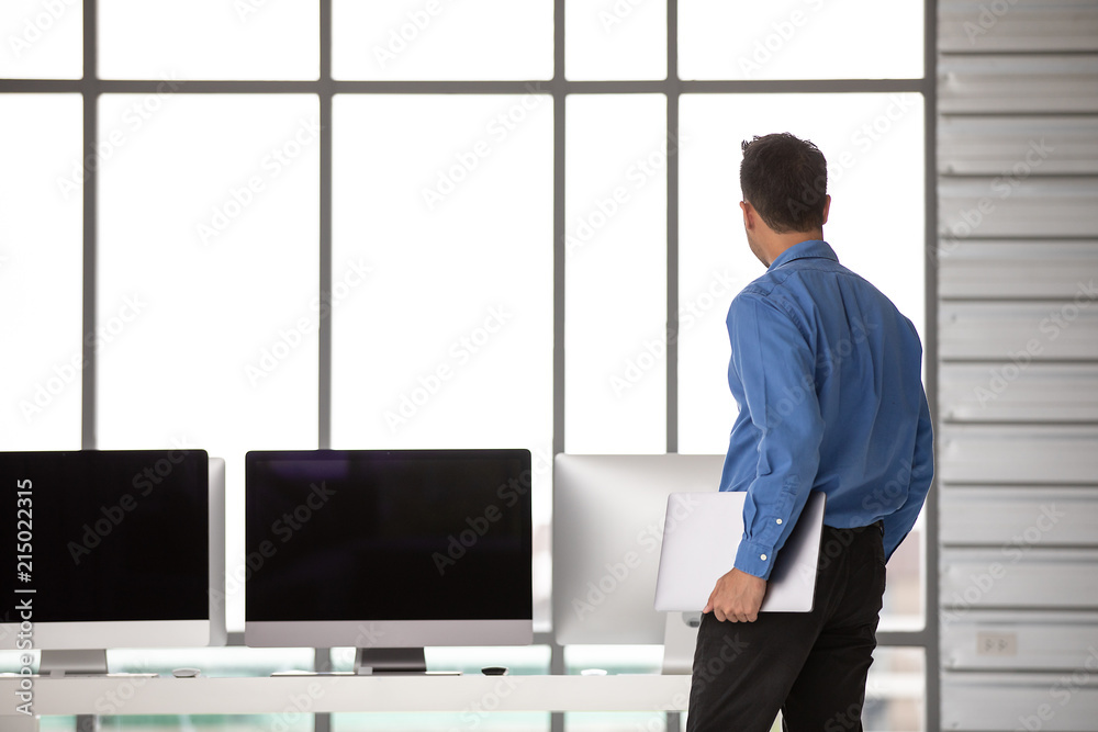 Young Asiabn businessman standing and holdin new laptop computer with ...