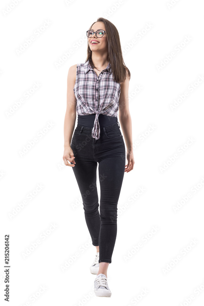 Smiling young cheerful cool modern woman walking towards camera and ...