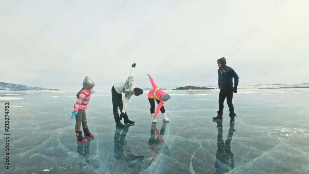 Family do sports exercises on ice in nature. Father training his family ...