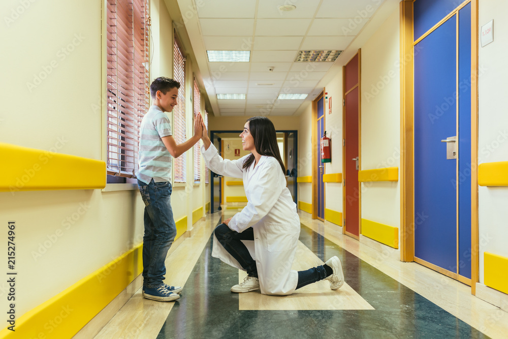 Doctor woman giving a high five to her young patient Stock Photo ...