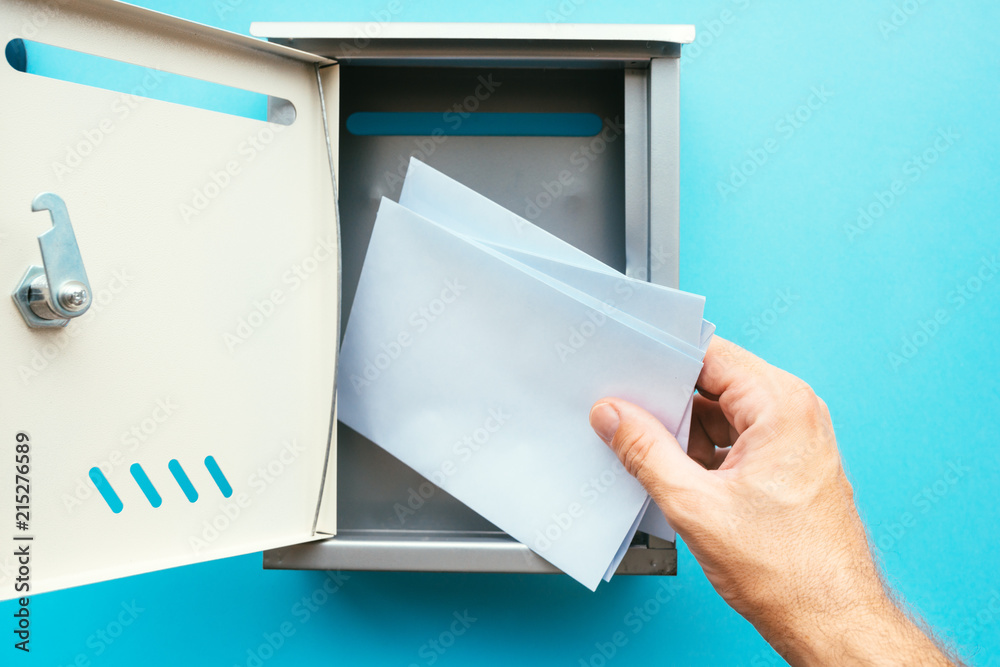 Hand inserting letter envelope into mailbox Stock Photo | Adobe Stock