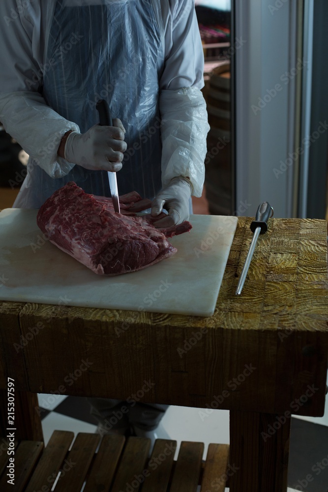 Butcher cutting meat at butcher shop Stock Photo | Adobe Stock