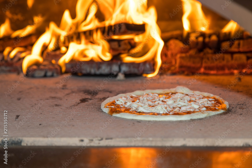 The working furnace for preparation of pizza. Inside burns firewood and ...