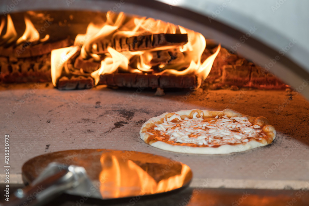 The working furnace for preparation of pizza. Inside burns firewood and ...