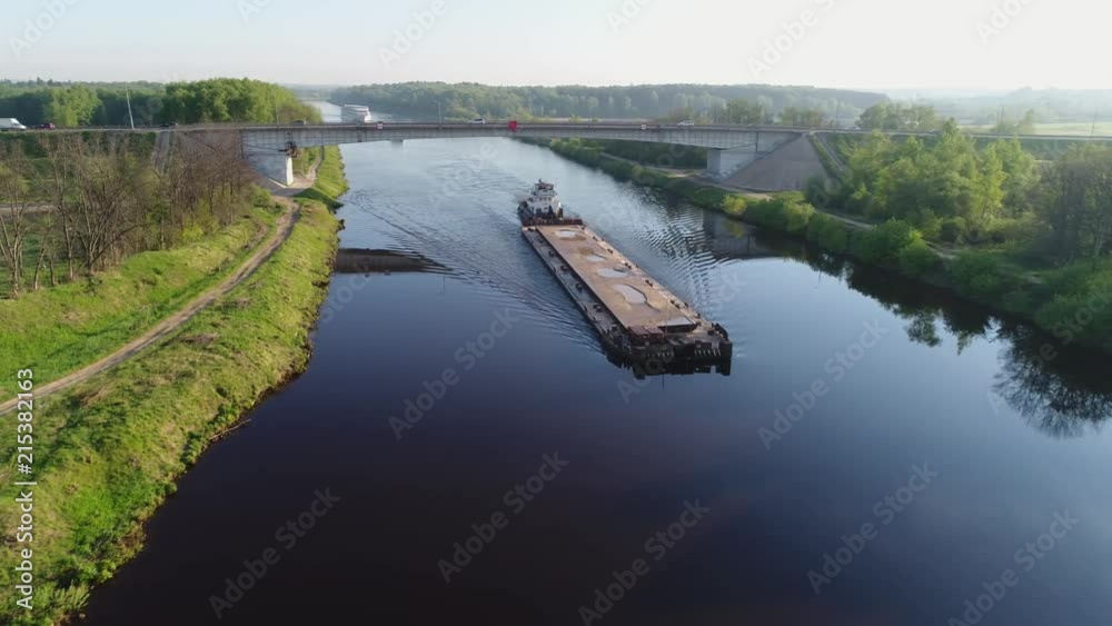 Aerial view. The tug and the barge loaded with river sand swims under ...