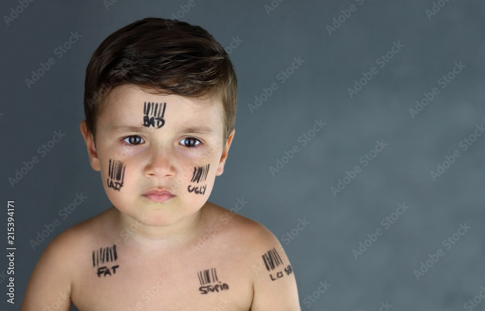 sad child who suffer bullying with bar code and insults in his face in ...
