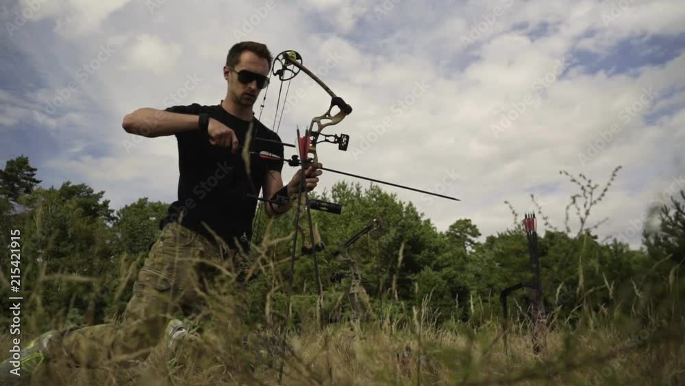 Slow motion low angle of an arching kneeling on one knee aiming and ...