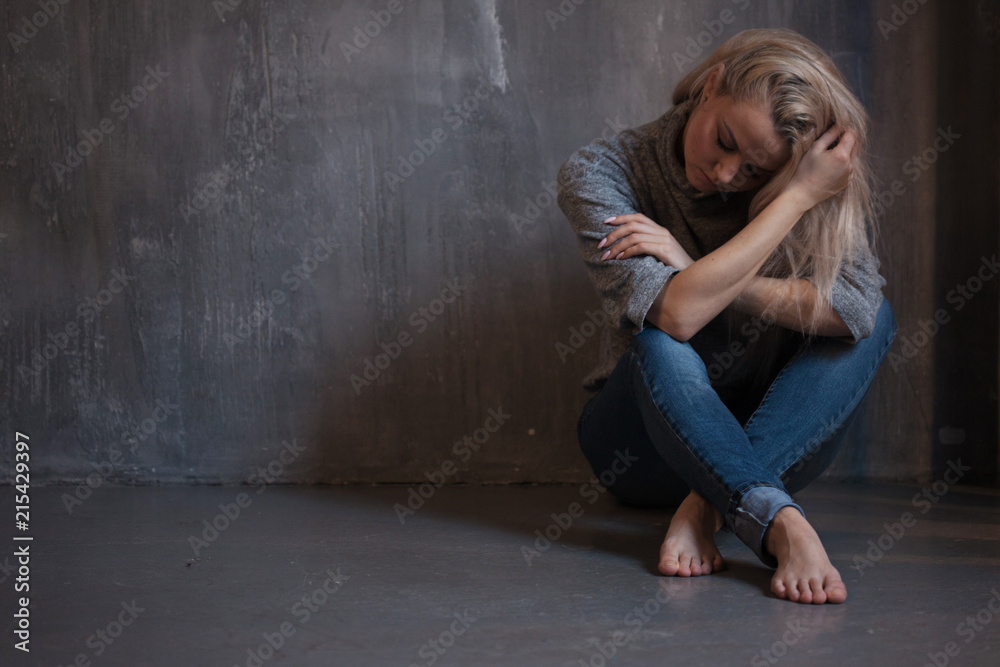 Depressed woman. blonde girl sitting on the floor, sadness and ...