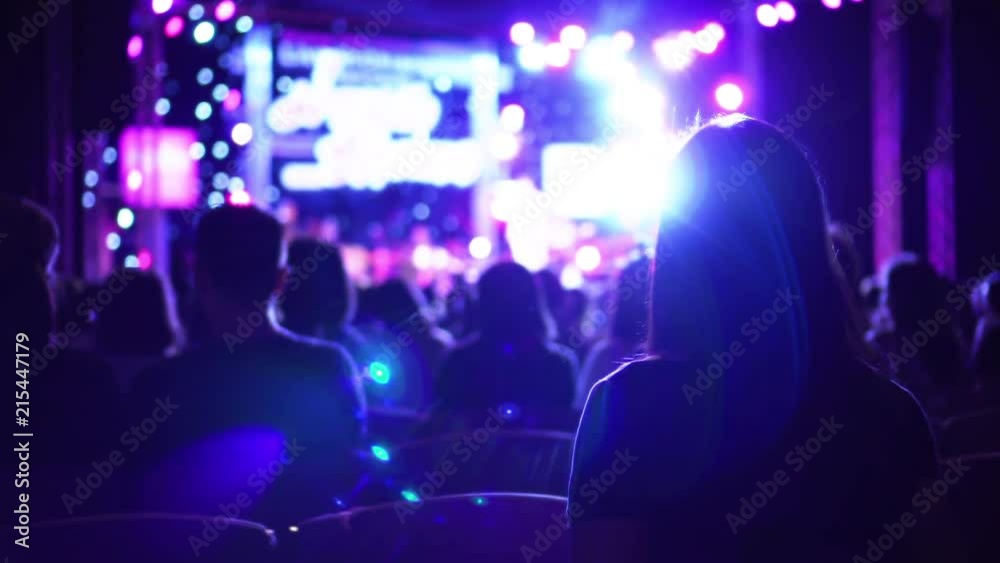 Some female sit quiet in concert party with crazy flashing lights show ...