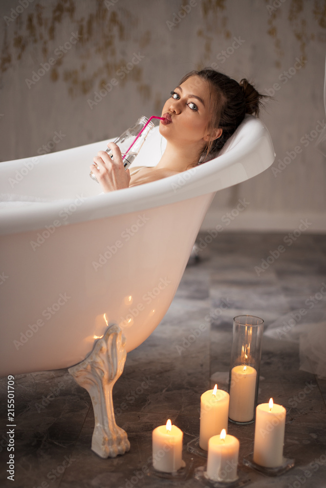 gorgeous girl slogging down in the bath with foam. side view photo ...