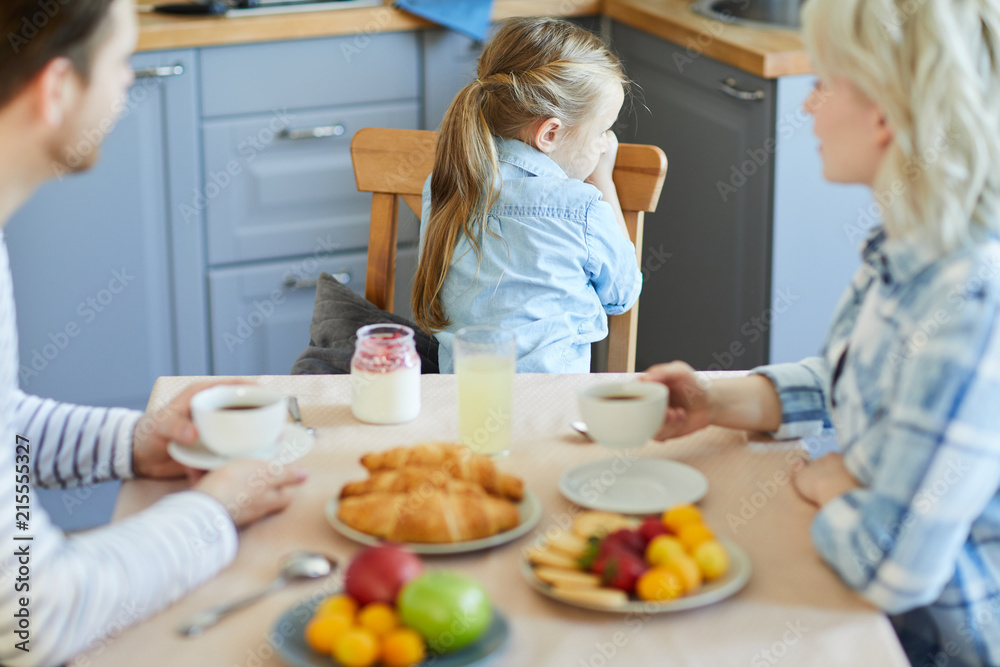 Offended little girl turning off table while her parents having ...
