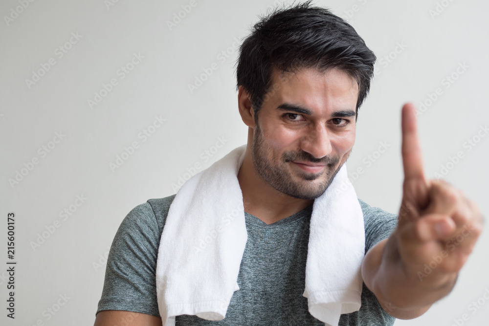 confident fitness man pointing up one finger; portrait of happy ...