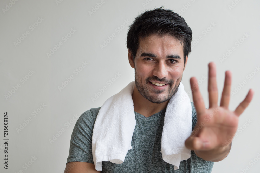 confident fitness man pointing up four finger; portrait of happy ...