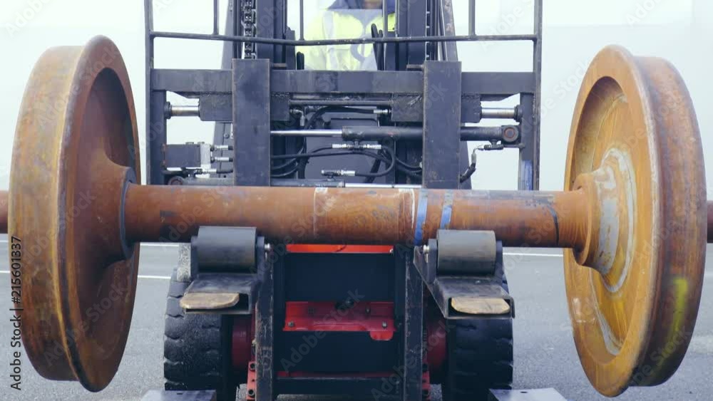 Lifting train wheelbase from an iron pallet with forklift 4K. Wide view ...