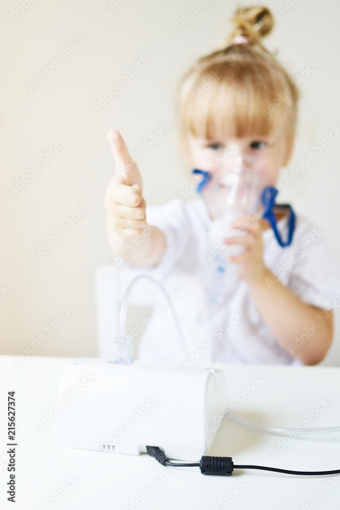Little girl in a mask for inhalations, making inhalation with nebulizer ...