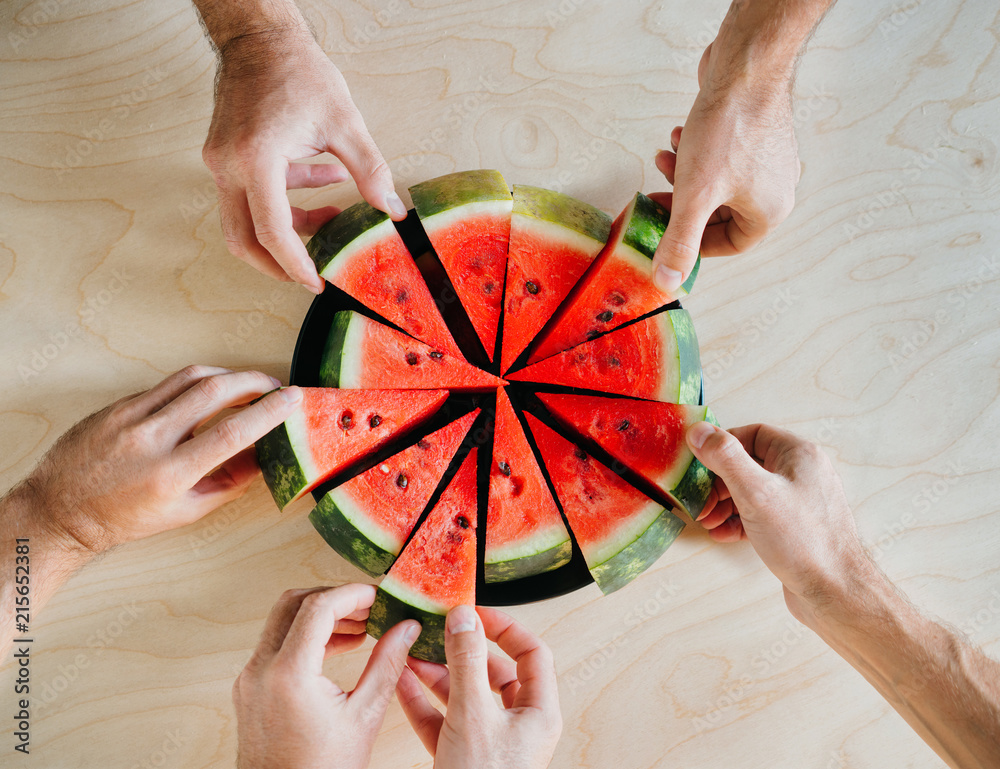 Red Watermelon is cut in equal parts, to which stretch from all sides ...