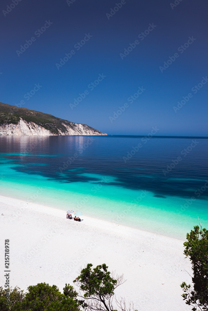 Fteri beach Kefalonia, Greece. Family under umbrella on pebble beach ...