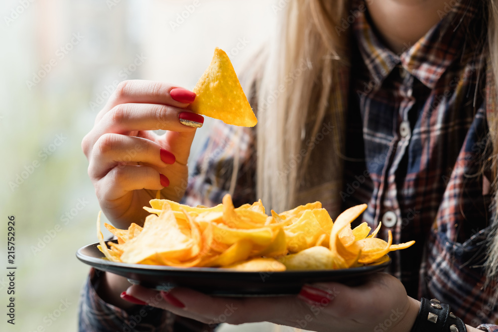 unhealthy fast food snacks. bad nutrition habits. woman eating crispy ...