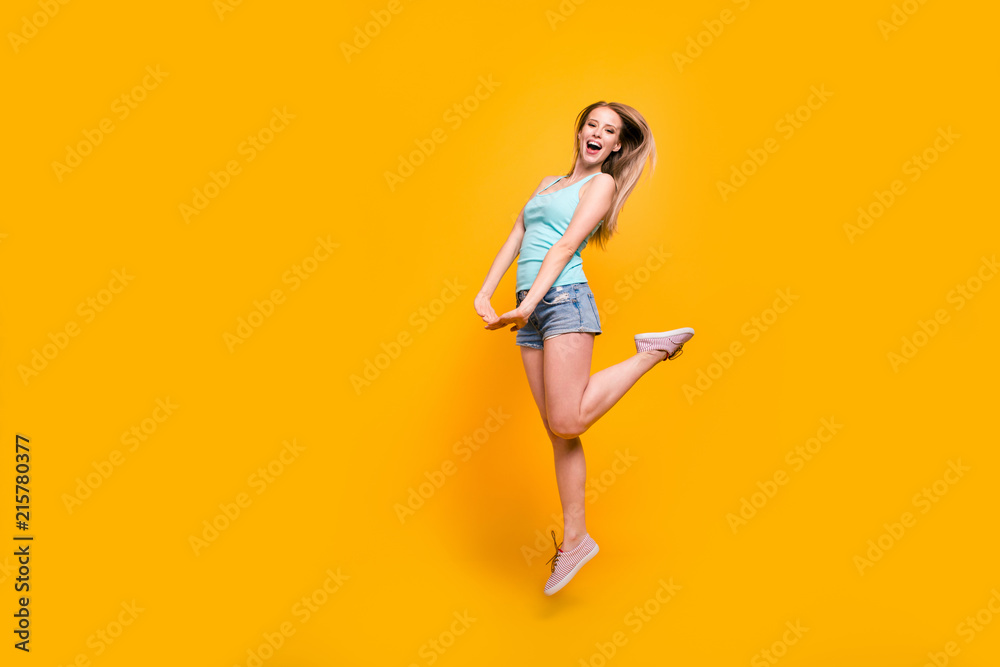 Full-body portrait of gorgeous blond model jump high and rejoice ...