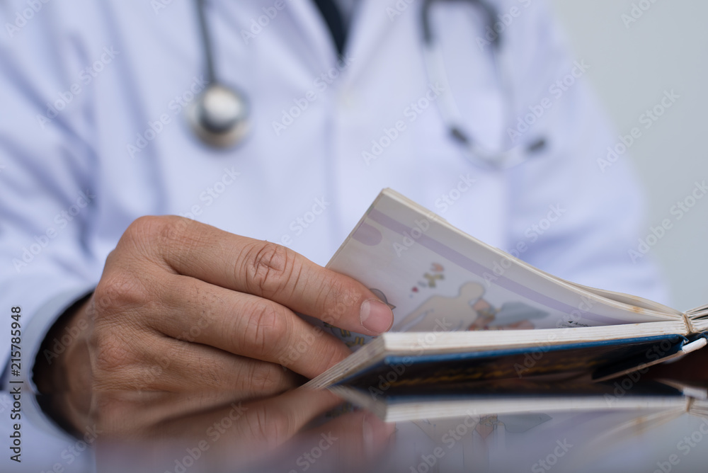 Doctor reading textbook Stock Photo | Adobe Stock