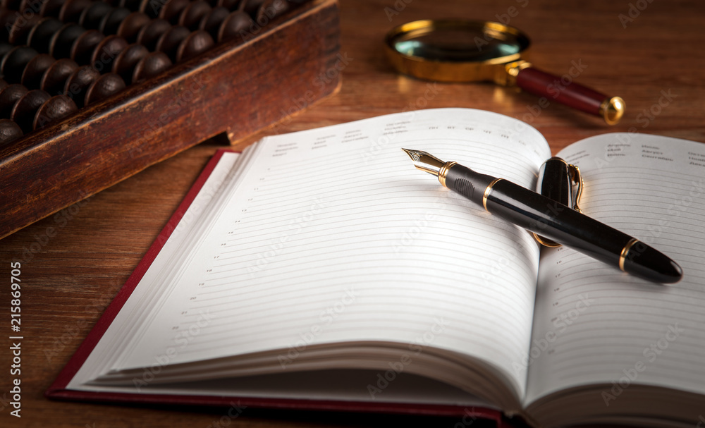 fountain pen and diary on a table with an abacus and loupe Stock Photo ...