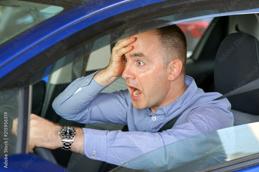 Side window view of inexperienced anxious motorist. Young man driving a ...