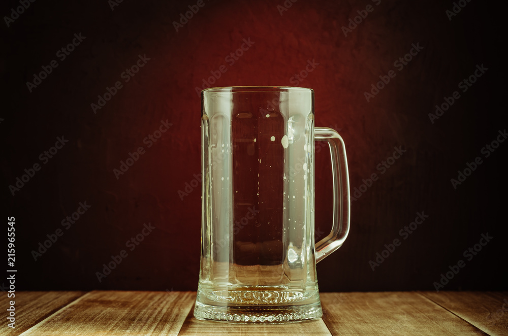 empty a glass from beer on a red light background/empty a glass from ...