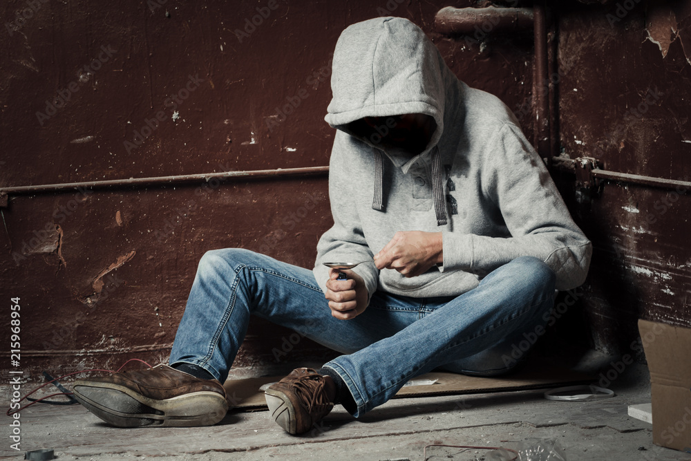 The hands of a drug addict melting cocaine in a spoon. A man holds a ...
