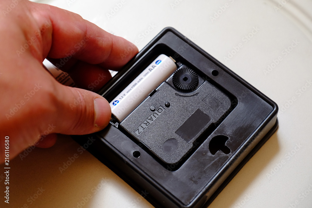 replacing the battery in a quartz wall clock Stock Photo | Adobe Stock