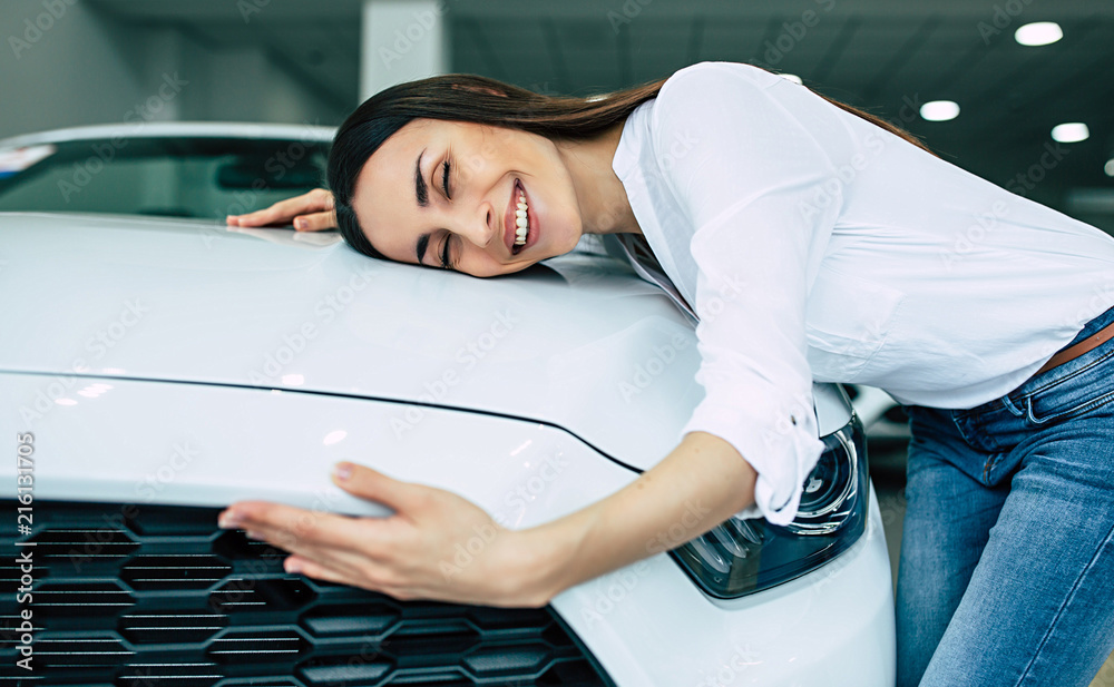Foto de Cute woman buying a new car for job and travel in dealership ...