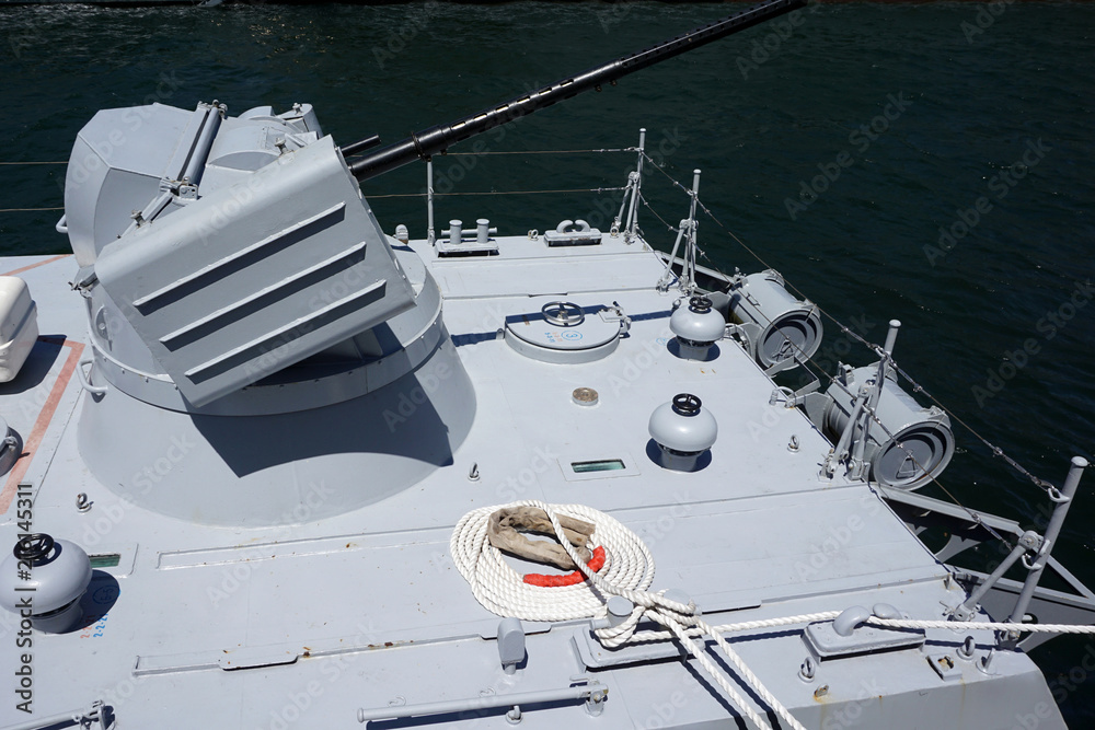 Naval ship artillery gun barrel on a blue sea background. copy space ...