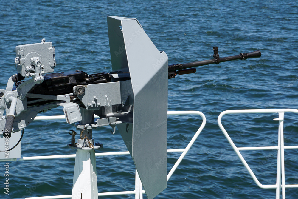Naval ship artillery gun barrel on a blue sea background. copy space ...
