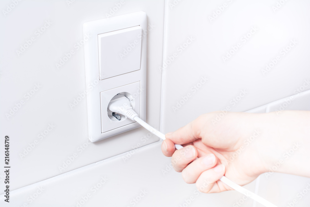 Pulling An Electrical Cable Out Of A Wall Socket To Save Energy Stock ...