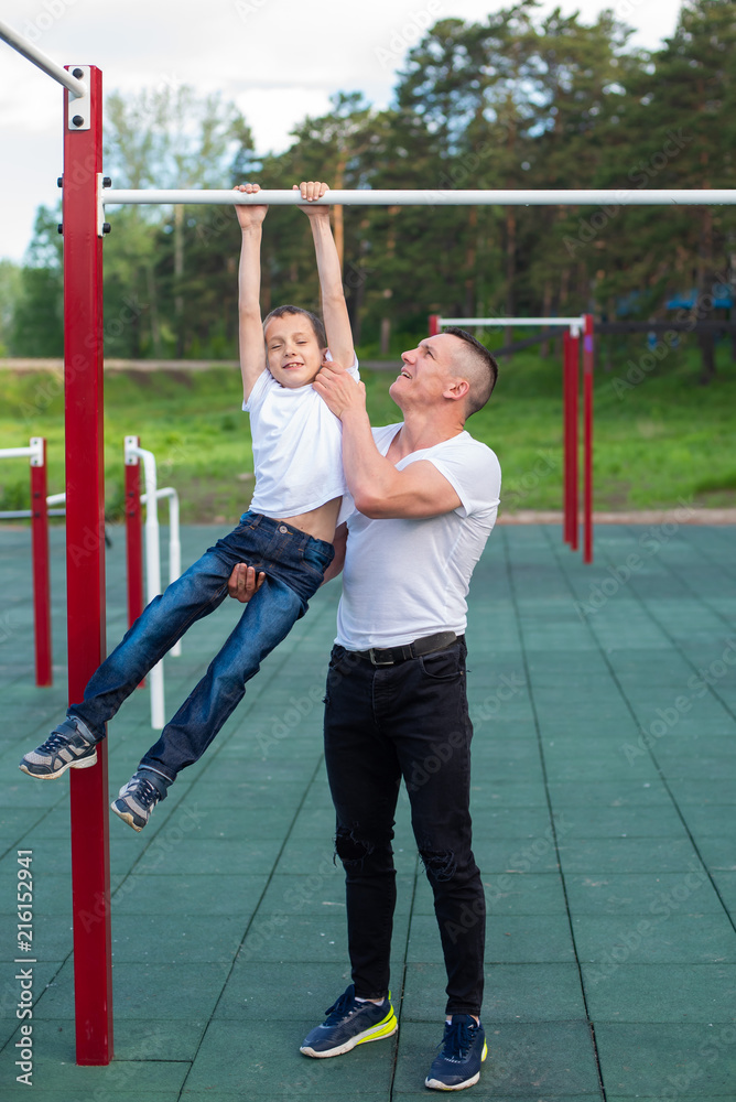 A strong athletic father insures the boy on sports equipment and ...