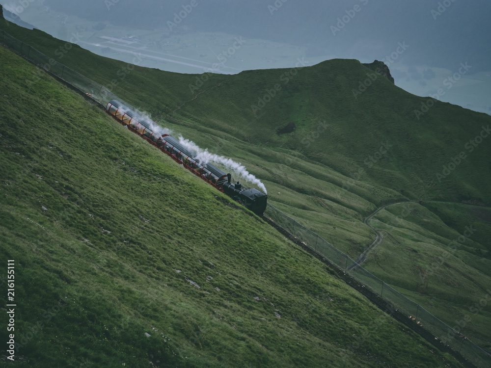 old steam train on a mountain track in the alps, brienzer rothorn bahn ...