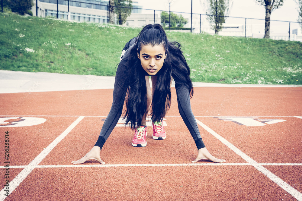 Ethnic woman running. Crouched in starting position. Multicultural ...