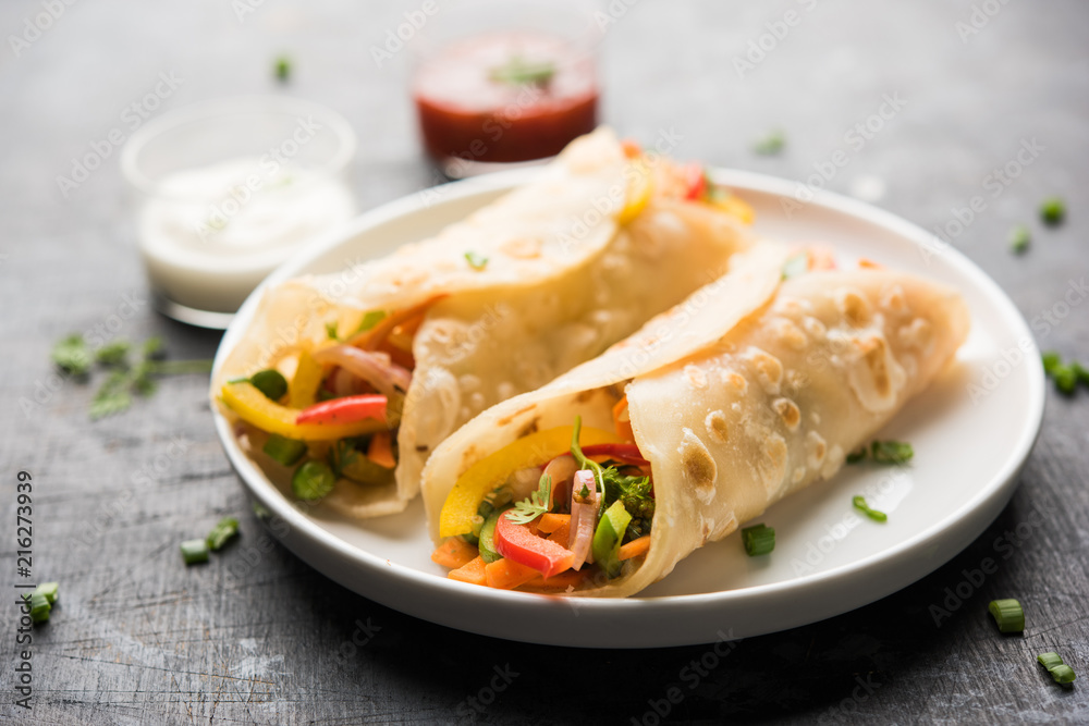 Indian Veg chapati Wrap / Kathi Roll, served in a plate with sauce over ...