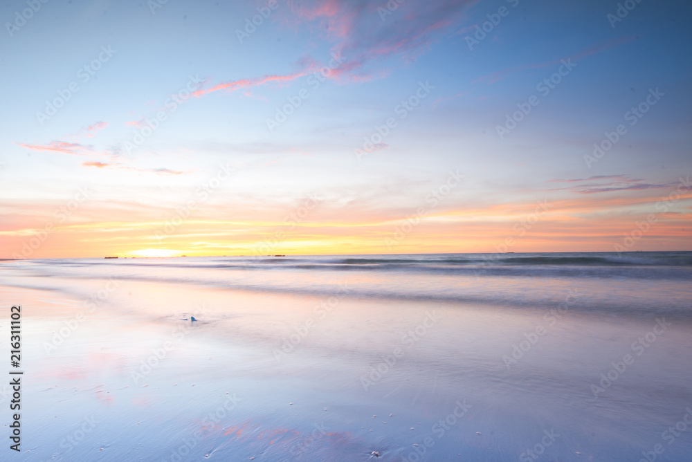 Beautiful and romantic sunset colour at the beach with reflection ...