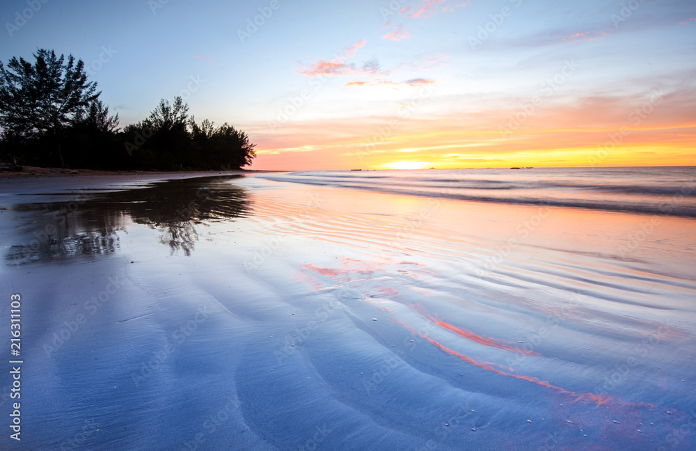 Beautiful and romantic sunset colour at the beach with reflection ...