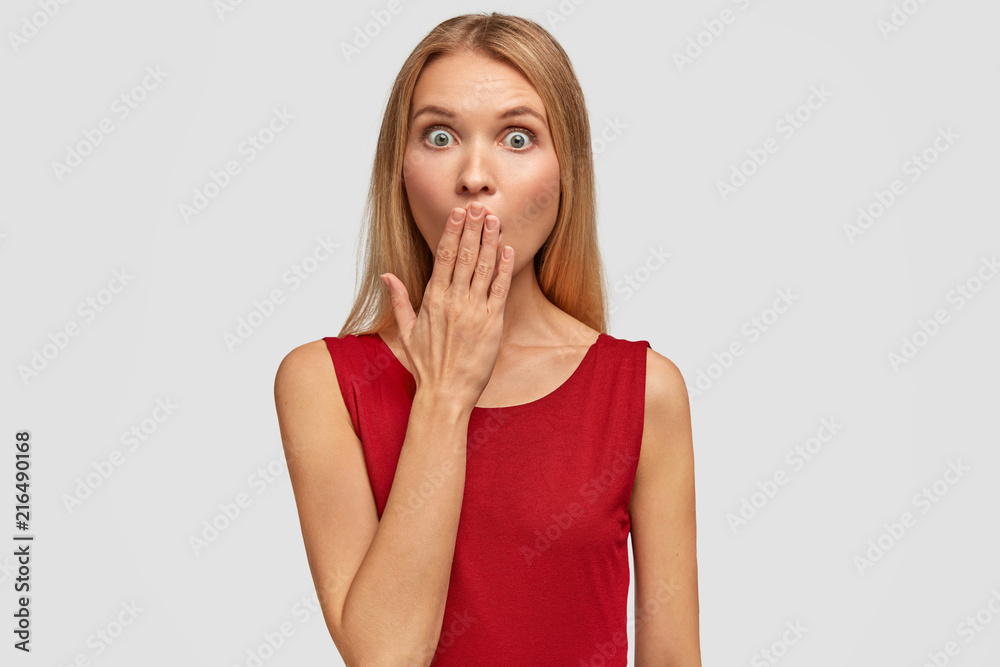 Worried beautiful blonde female gasps and wants to scream, covers mouth ...