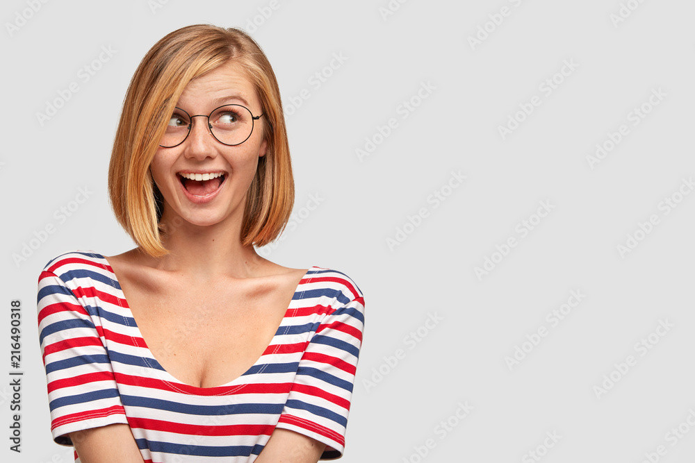 Cute pretty female has positive feelings, wears spectacles, striped t ...