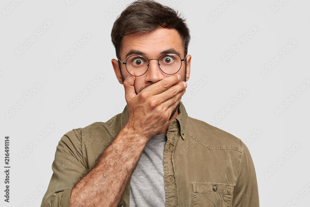 It`s awful! Stunned bugged eyed male with surprised expression, covers ...