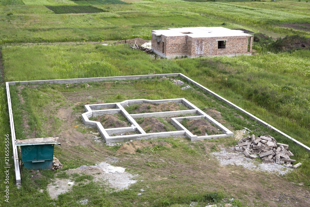 Building site in green field. Trenches dug in ground and filled with ...