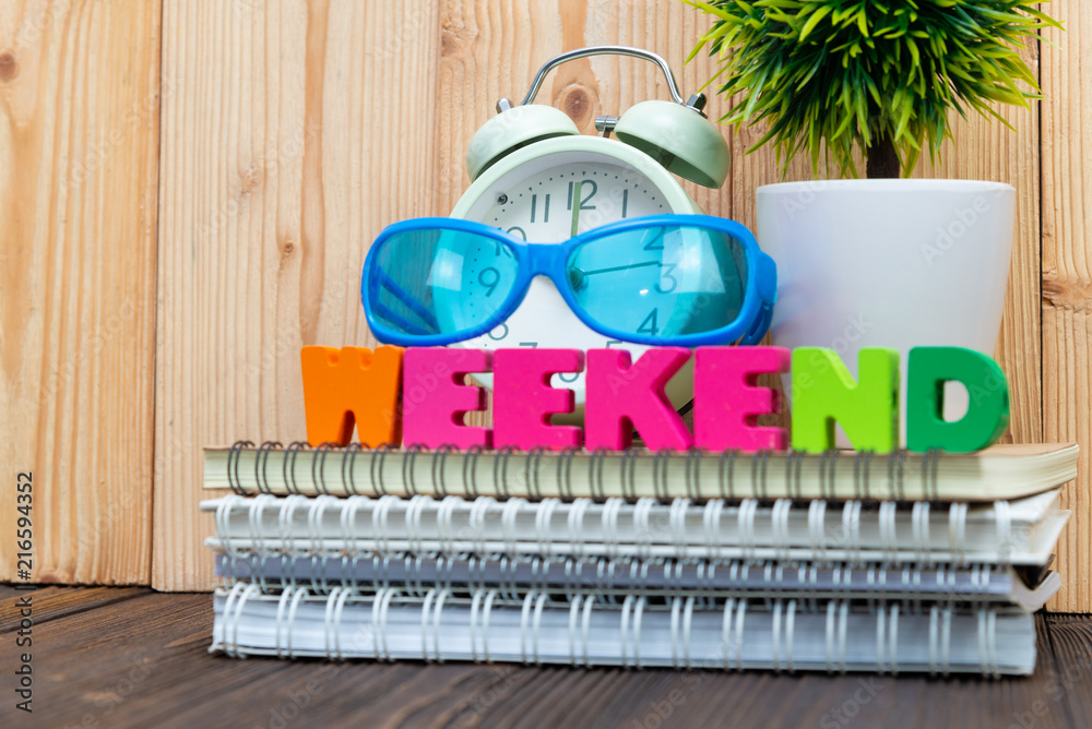 WEEKEND letters text and notebook paper, alarm clock and little ...