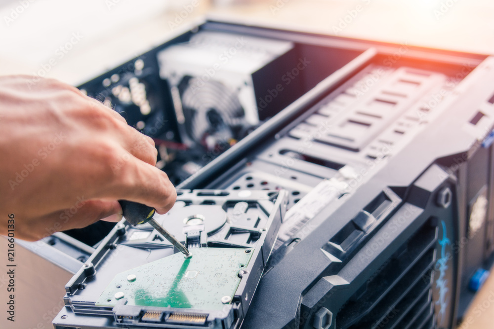The technician holds the screwdriver for repairing the computer. the ...