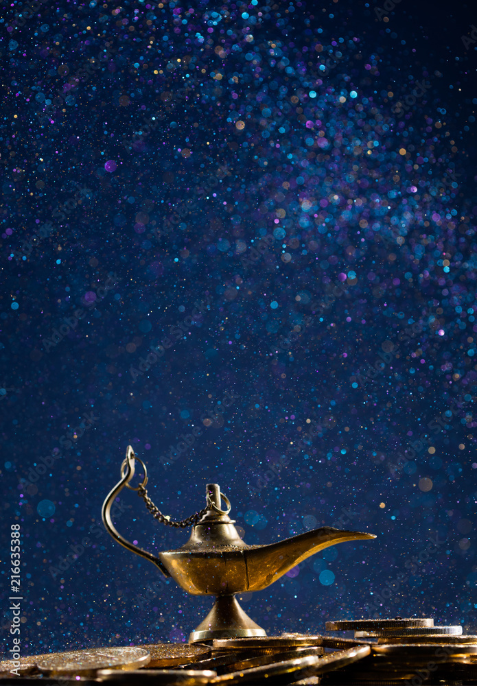 Magic lamp of wishes on stacks of gold coins with golden dust. Studio ...