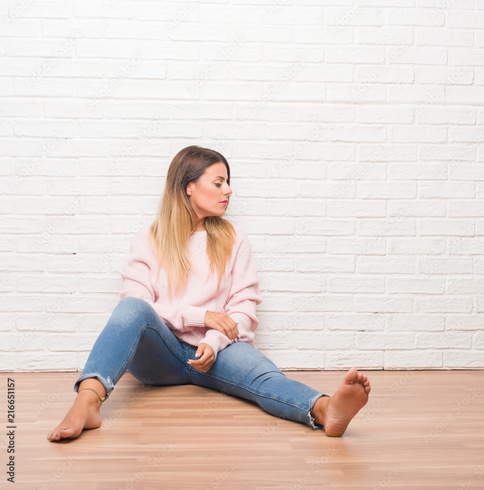 Woman Sitting Against Wall